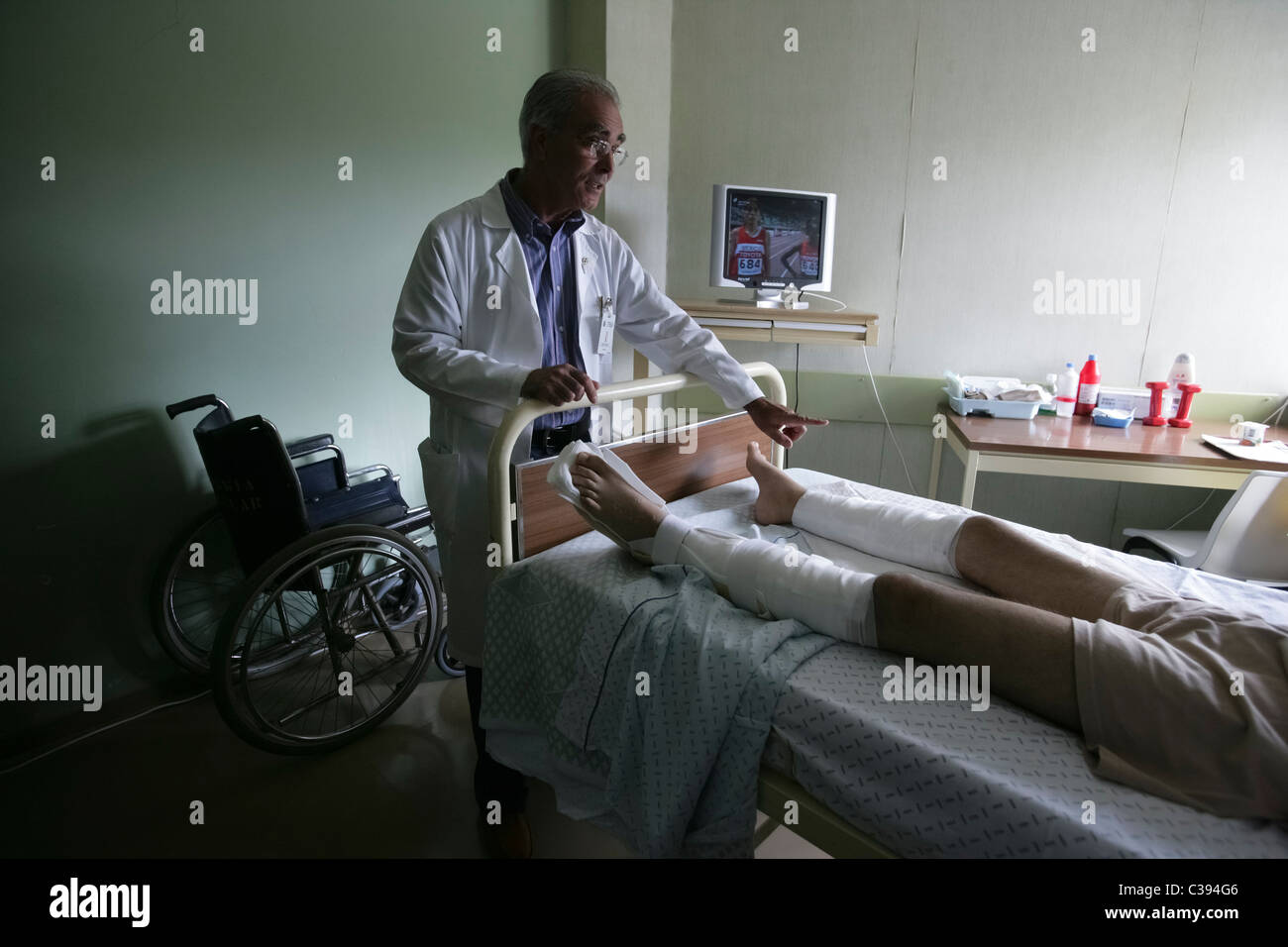 Doctor next to patient's bed in hospital ward Stock Photo - Alamy