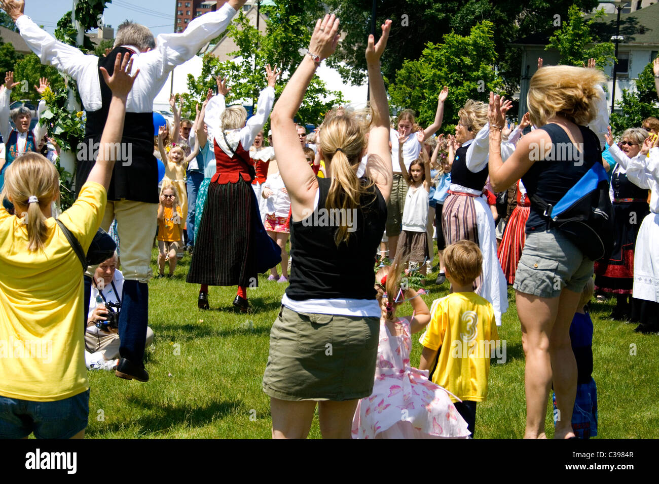 Maypole circle dance celebrants jumping during Midsommar Celebration at ...