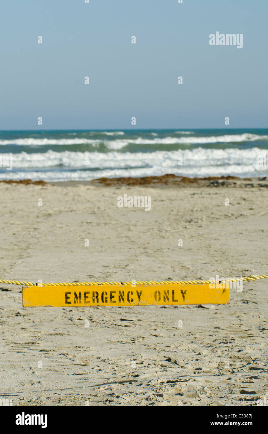 Emergency Only sign hanging on rope barrier limiting vehicle access to ...
