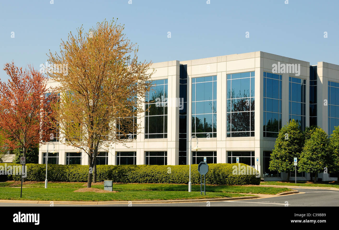 A modern office building surrounded by greenery and trees Stock Photo ...