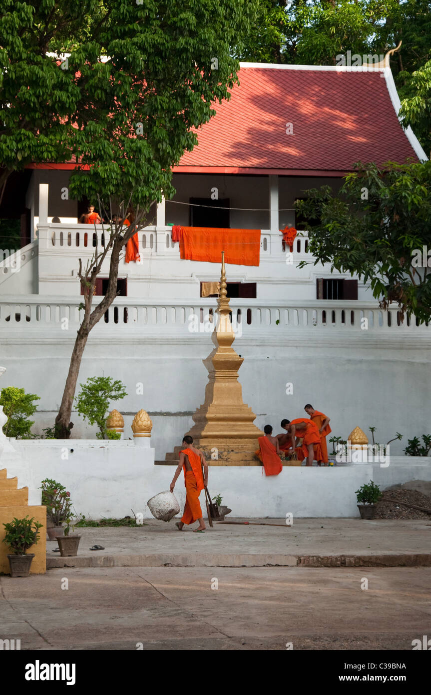 Monks going about their daily routine at a Buddhist temple in Luang ...