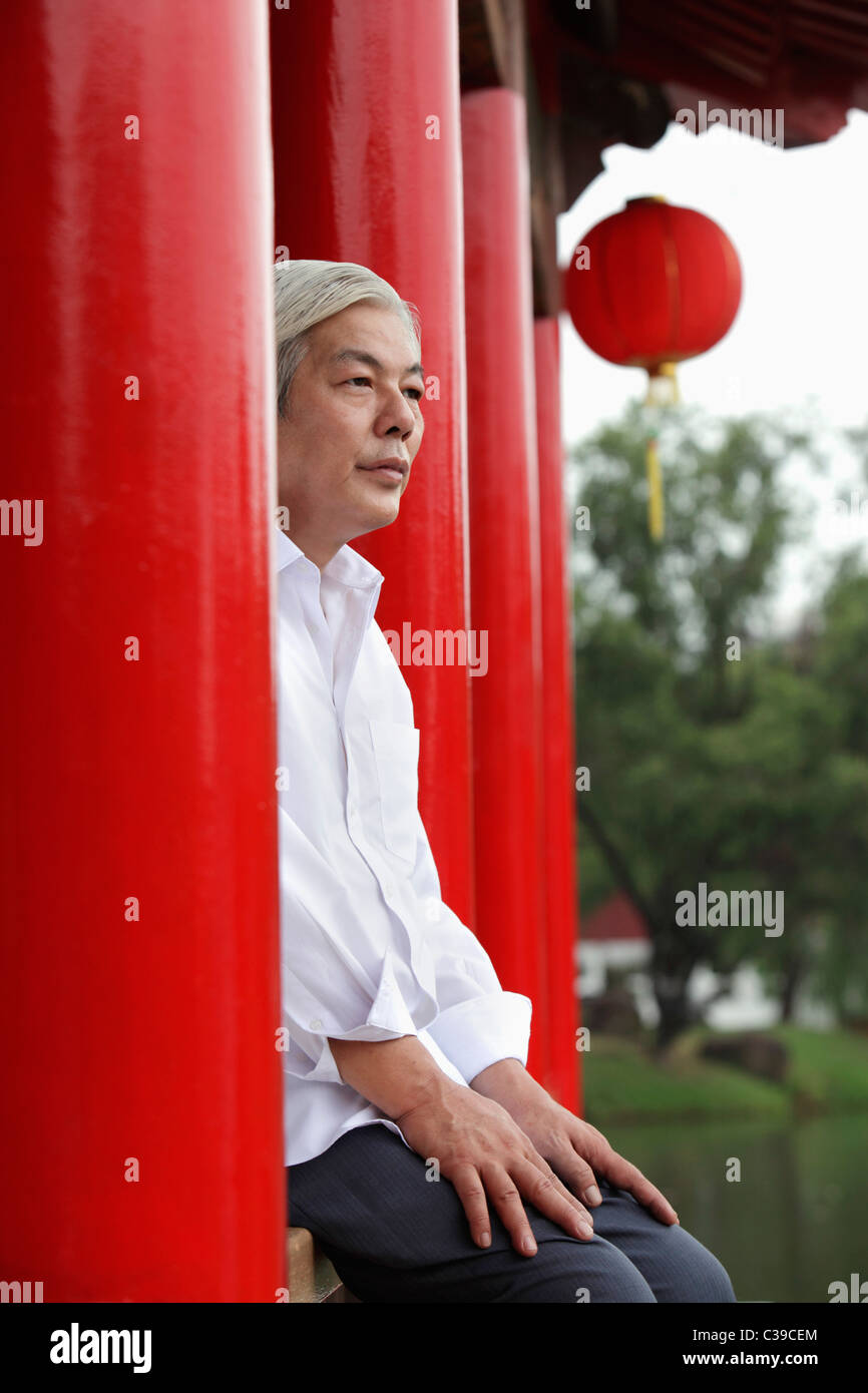 Older man sitting down at Chinese temple Stock Photo - Alamy