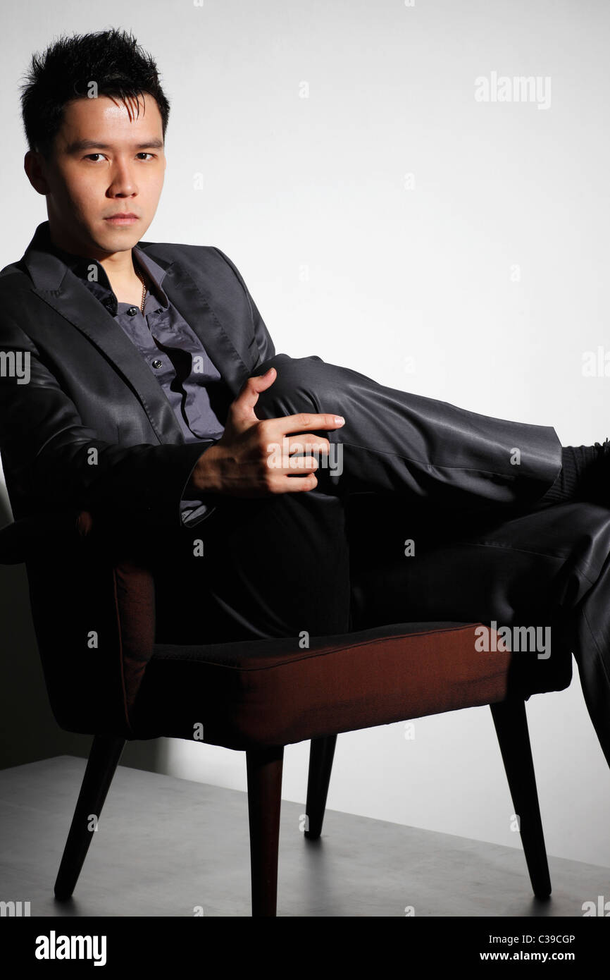 Chinese man sitting in chair Stock Photo - Alamy