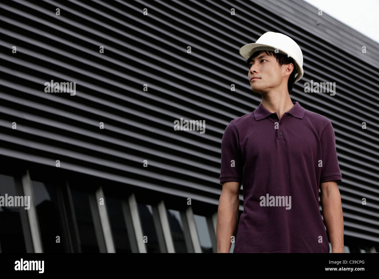 Chinese man with construction hat in front of building Stock Photo - Alamy