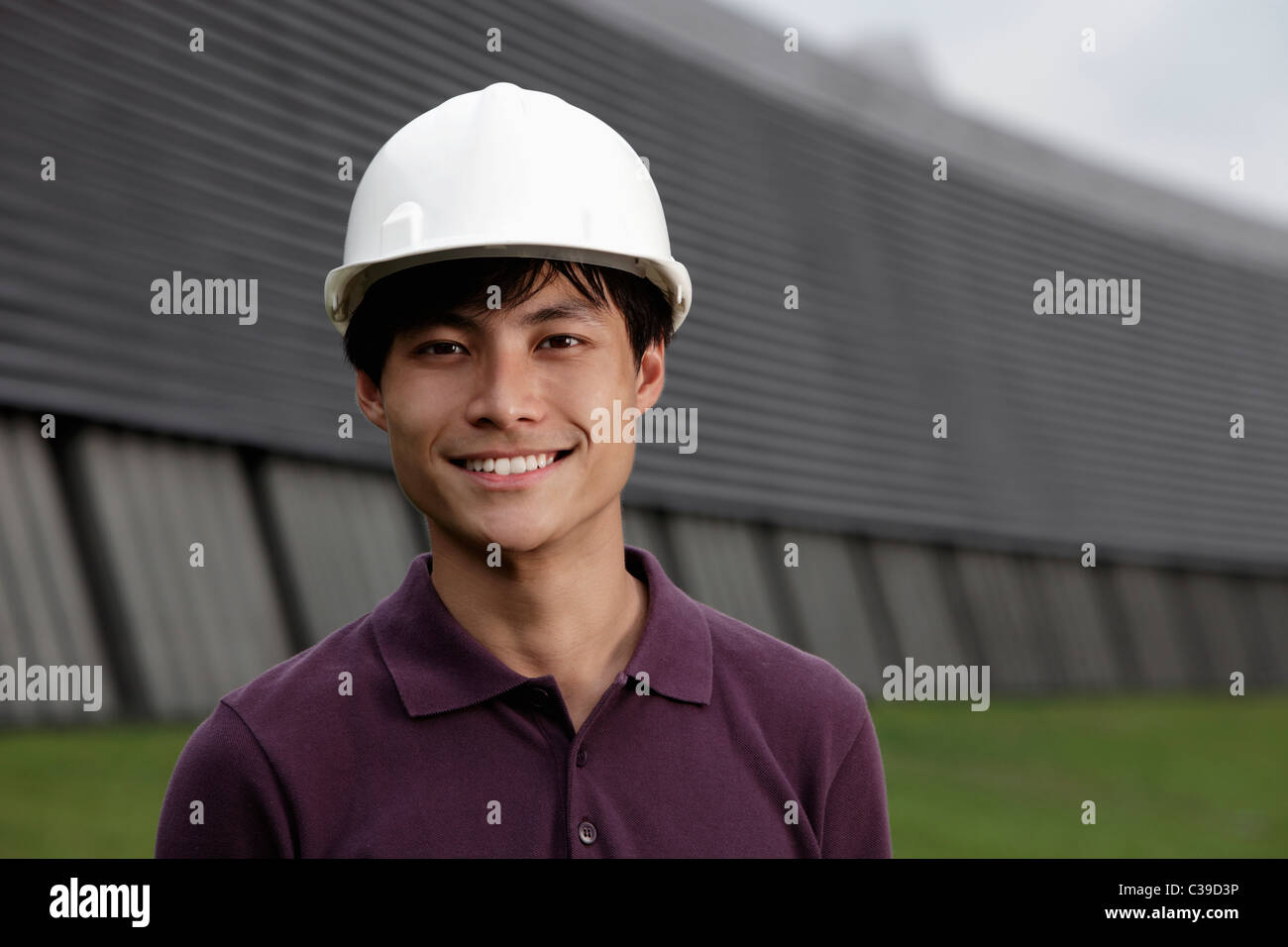 Chinese man wearing construction hat smiling Stock Photo - Alamy