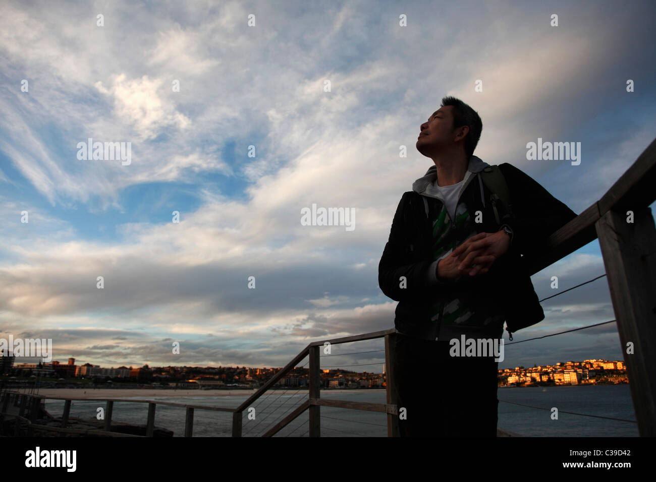 man leaning on railing while looking at the sky Stock Photo - Alamy