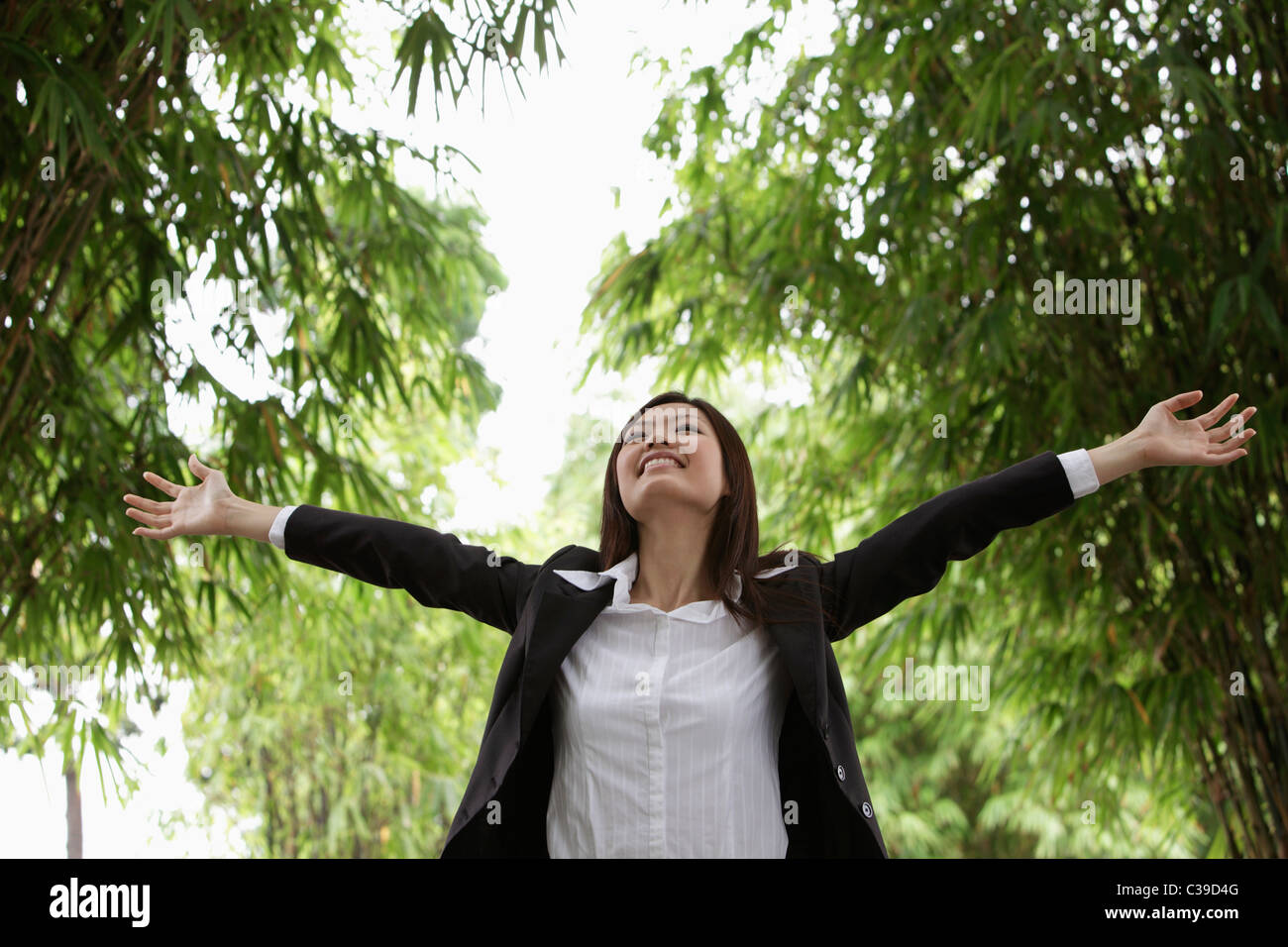 Young woman wearing a suit and raising her arms up outside Stock Photo ...