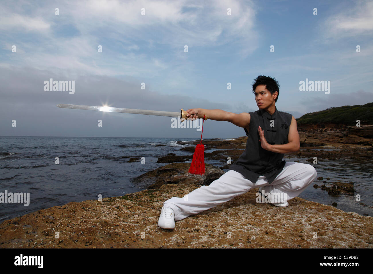 Chinese man doing martial arts and pointing sword Stock Photo - Alamy