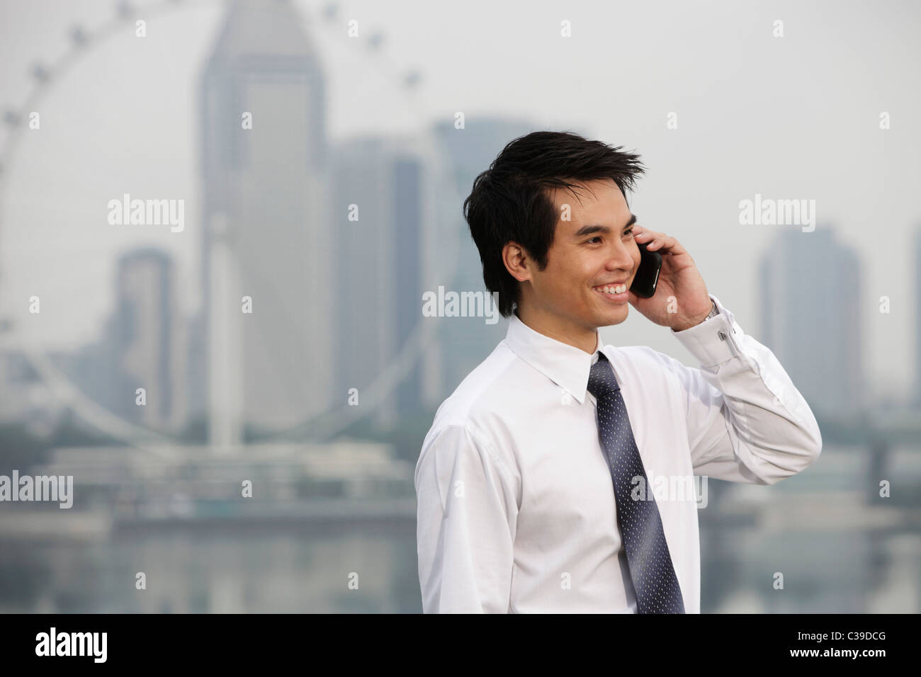Chinese man talking on phone in front of city sky line Stock Photo - Alamy