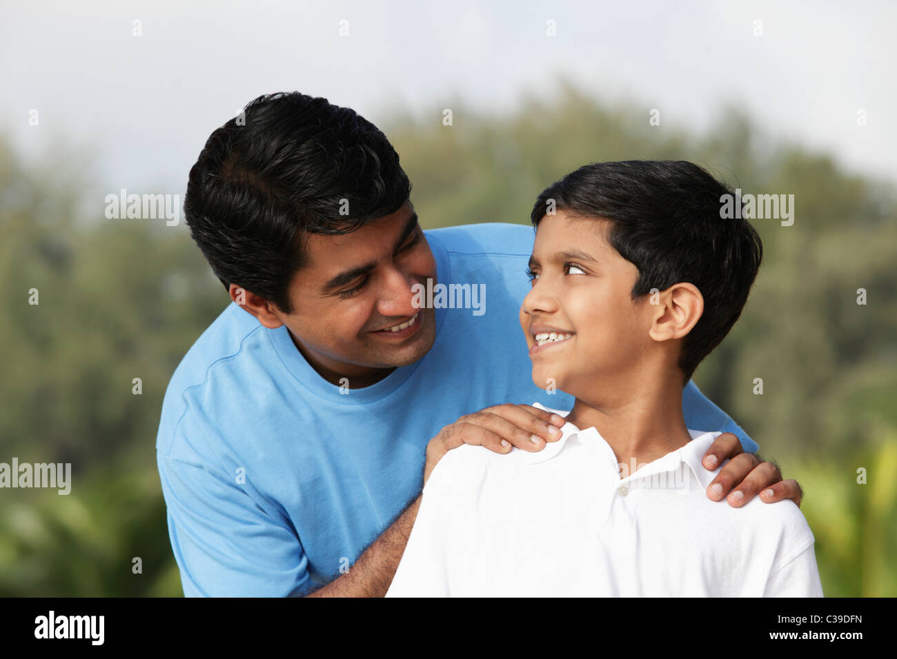 Father looking at son smiling Stock Photo - Alamy
