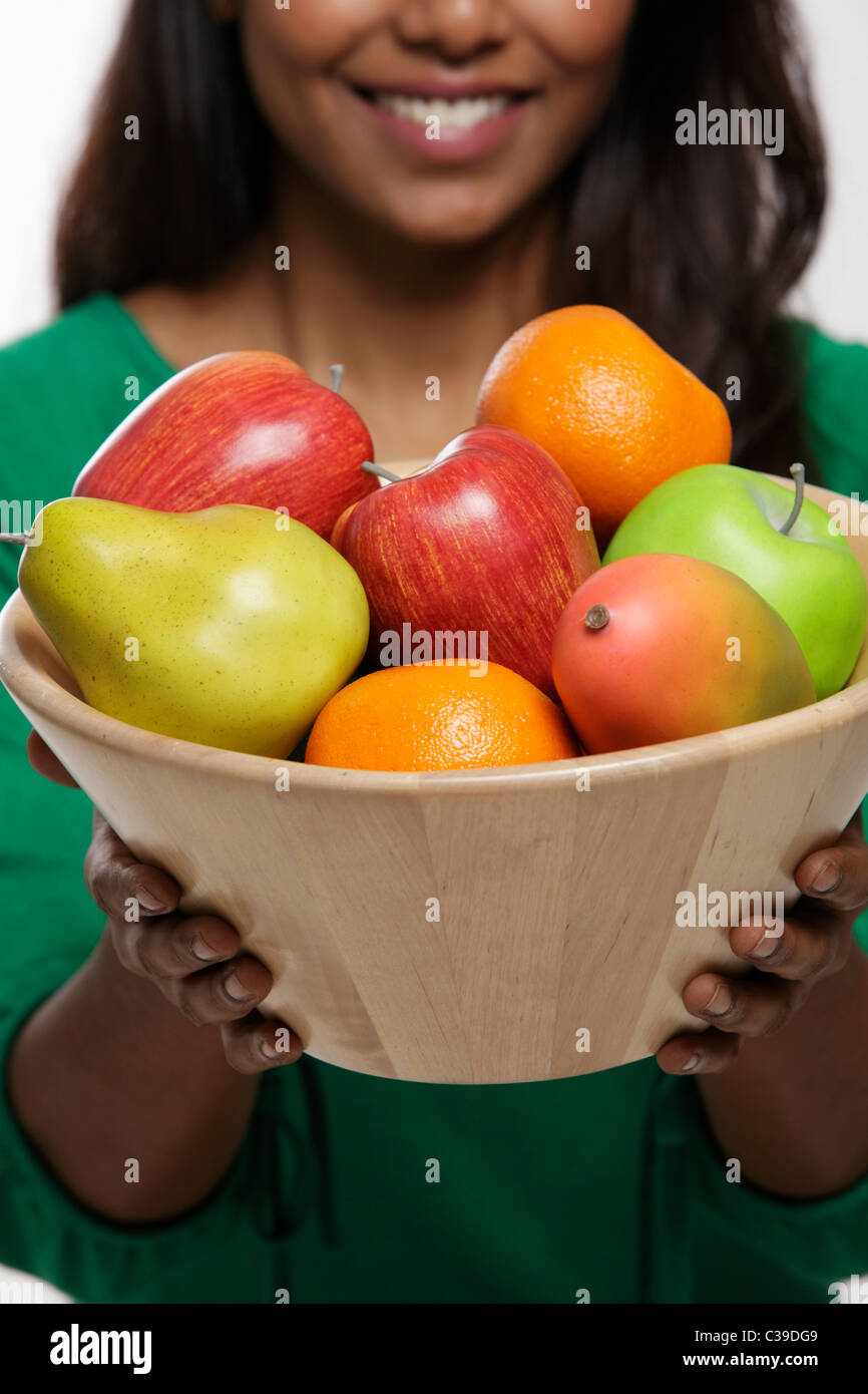 Young woman holding a bowl of fruit Stock Photo - Alamy