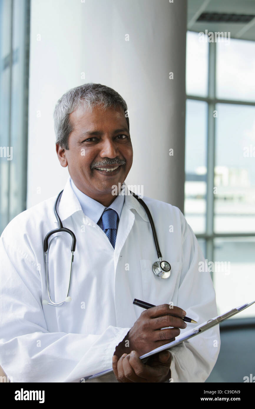 Indian doctor writing on clipboard Stock Photo - Alamy