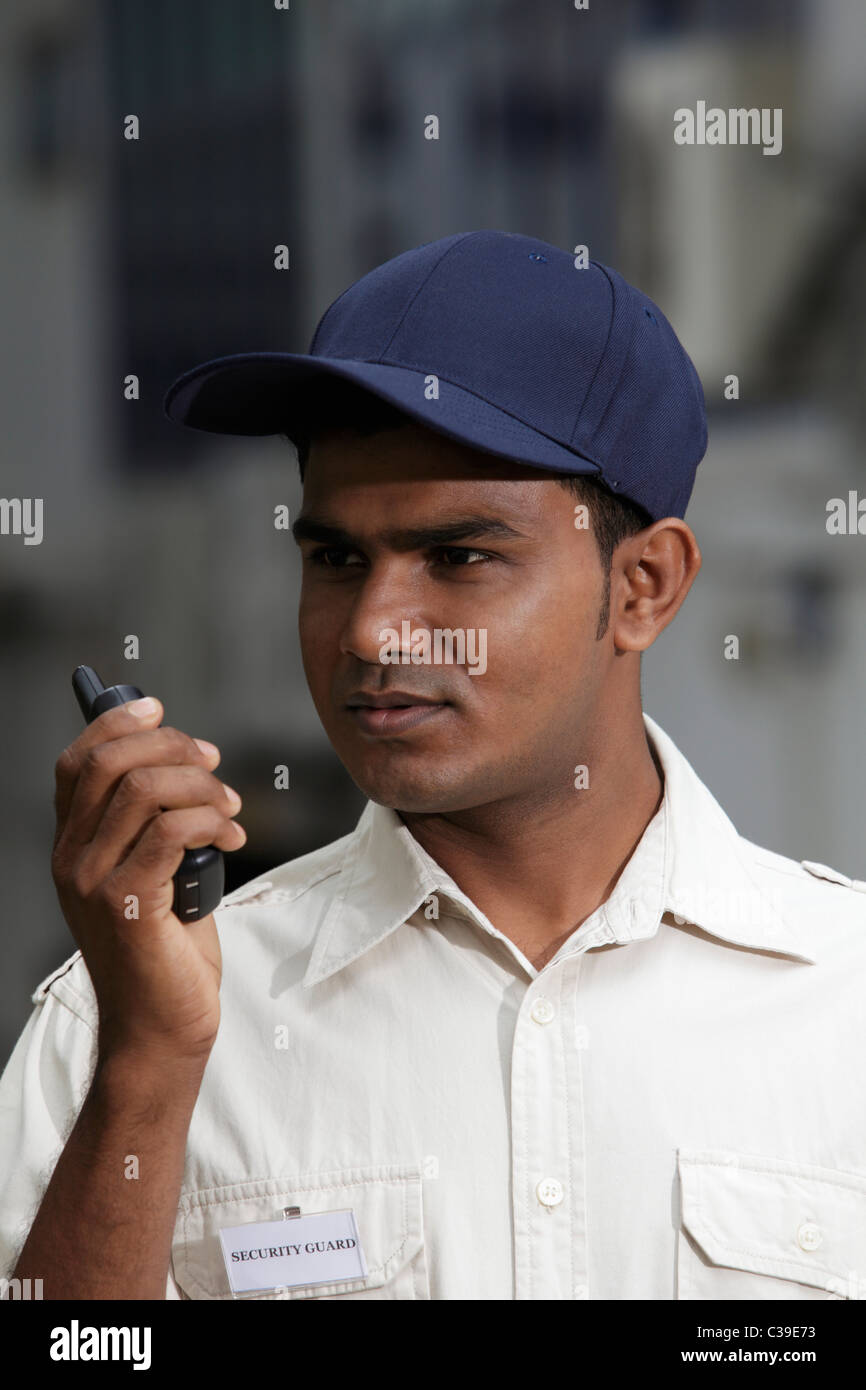 Security guard talking into walkie talkie Stock Photo - Alamy