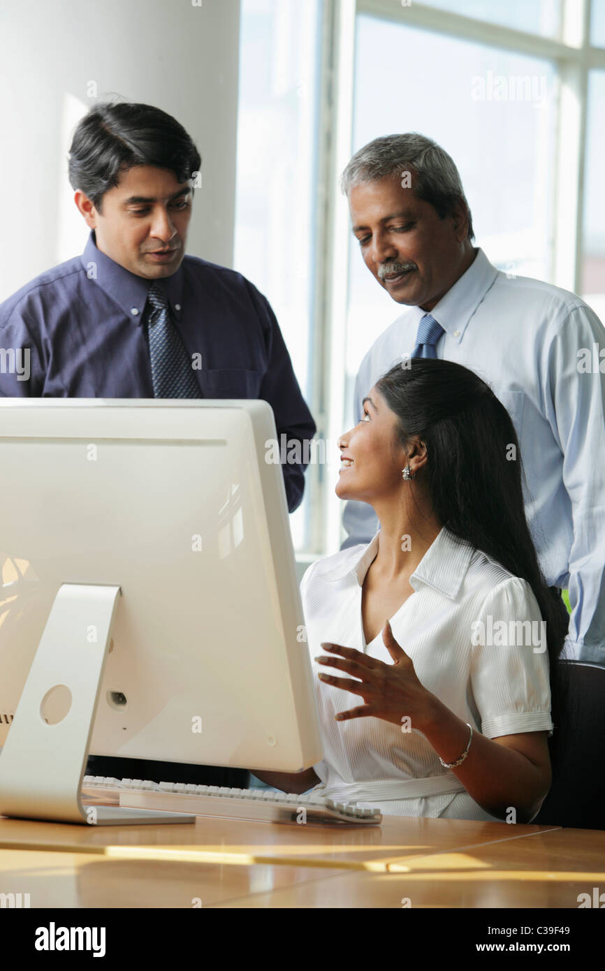 Indian business people talking to each other around a computer Stock ...