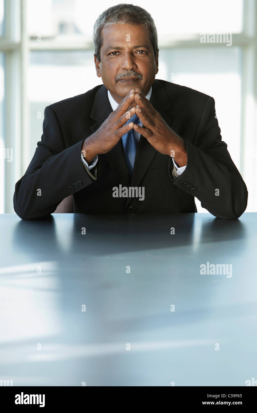 Indian business man sitting at table Stock Photo - Alamy