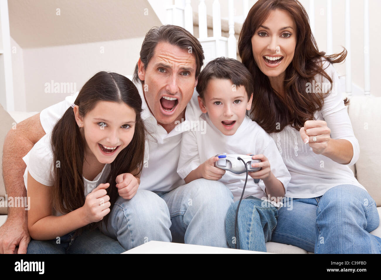 Happy family, parents, son and daughter, having fun playing video ...