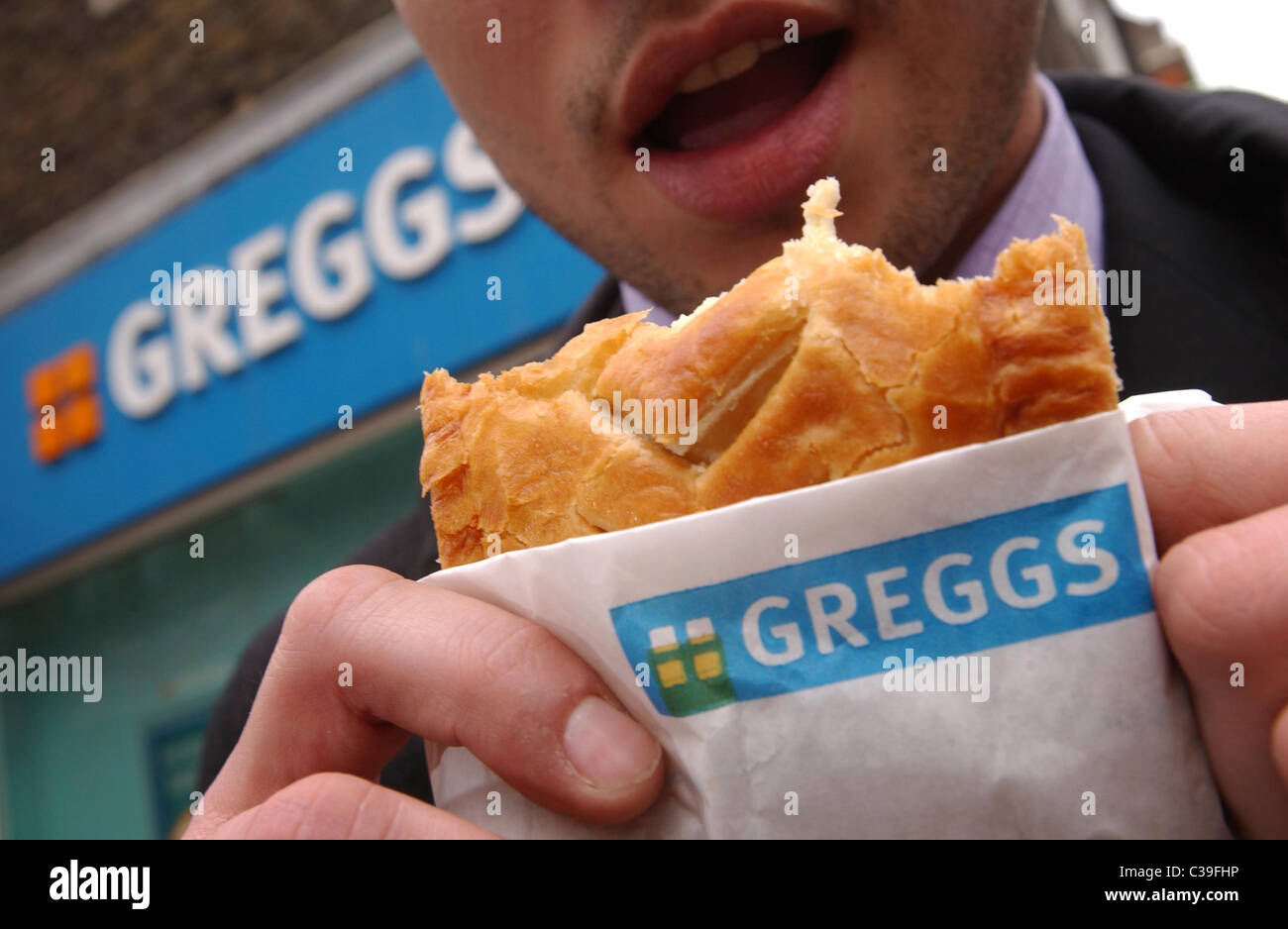 Picture shows: A city worker eating a Greggs pasty Stock Photo - Alamy
