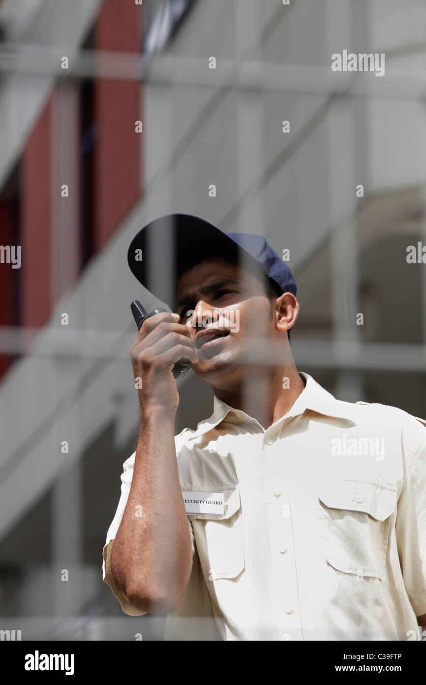Security guard talking on walkie talkie Stock Photo - Alamy