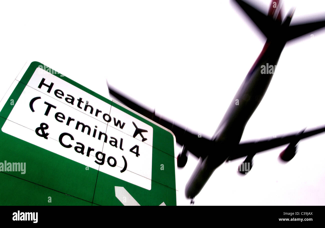 An aeroplane flying above road signs near Heathrow International ...