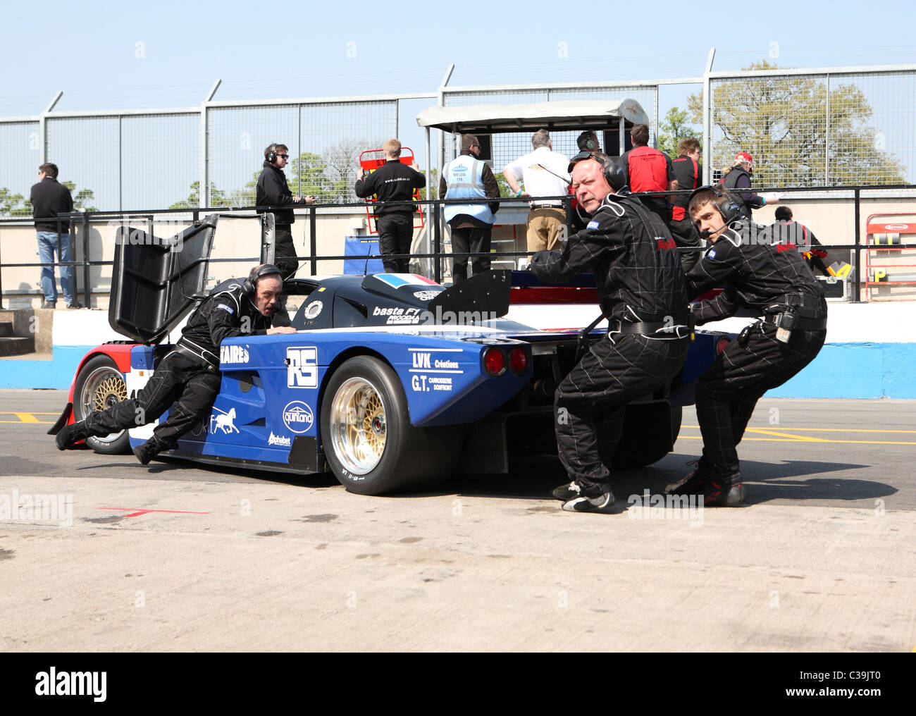 Pit crew pulling group C car back into the pit garage Stock Photo - Alamy