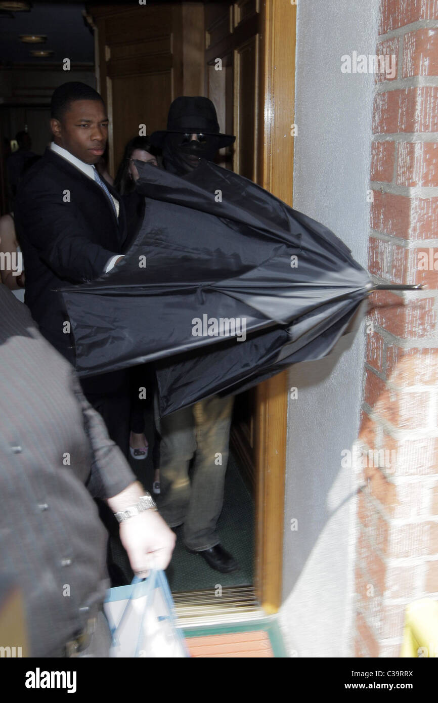 Michael Jackson hides his face under a black scarf, sunglasses and hat ...