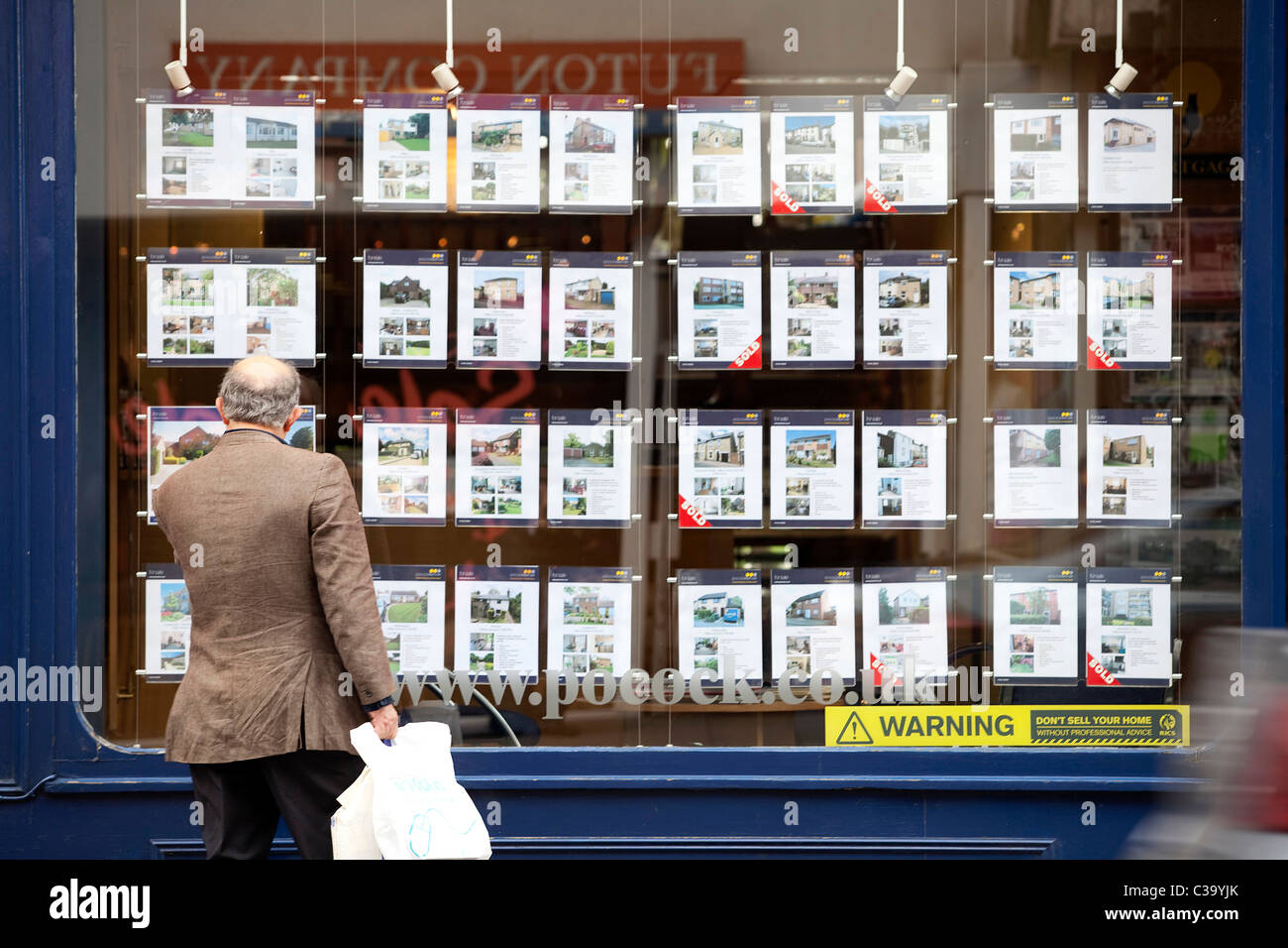 A person looks into the window of an estate agent Stock Photo - Alamy