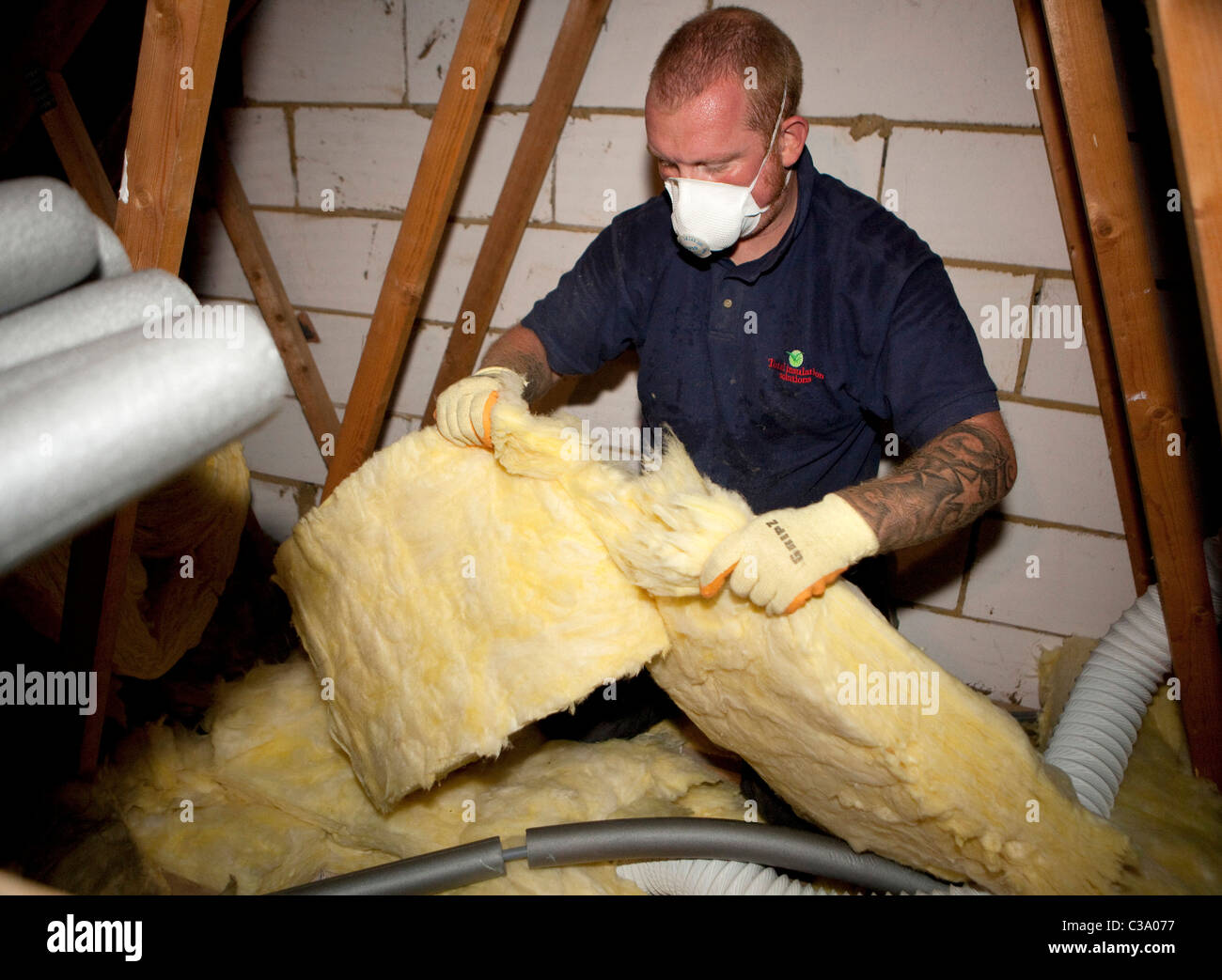 Illustrative image of loft insulation. A worker from Total Insulation ...