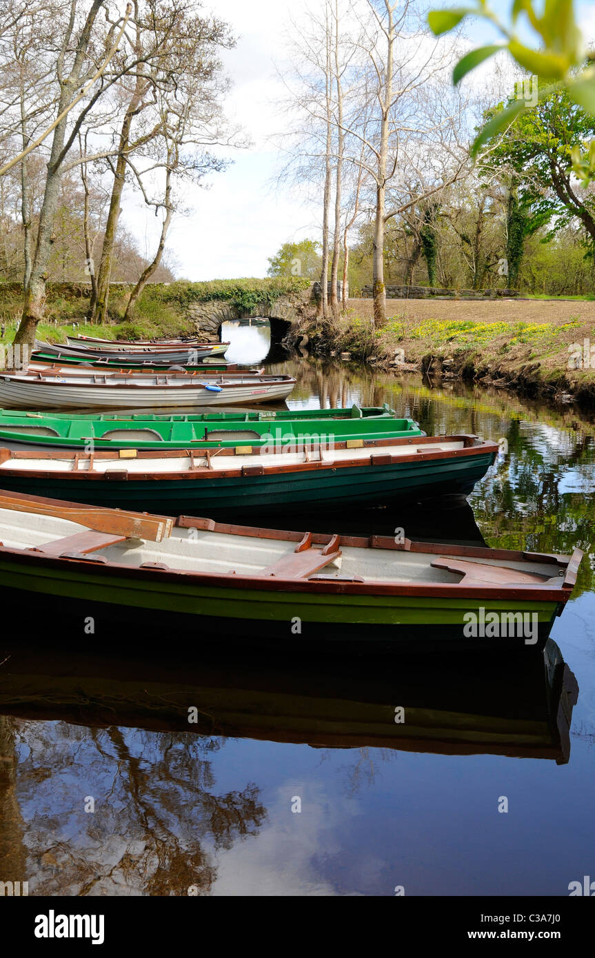 Small wooden rowing boats tied up on the banks of this small canal ...