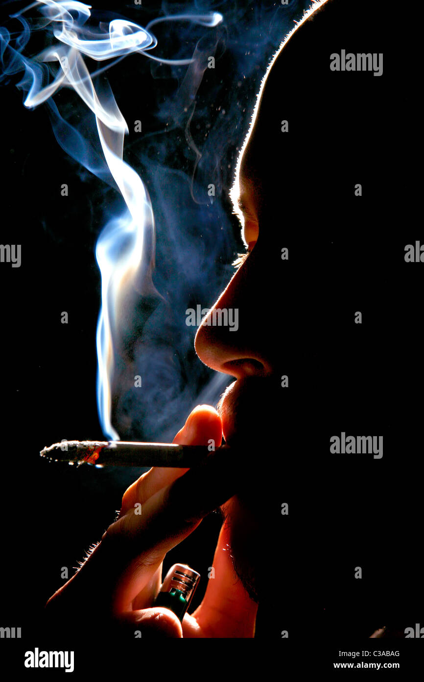 A silhouette picture of a man smoking a cigarette Stock Photo - Alamy