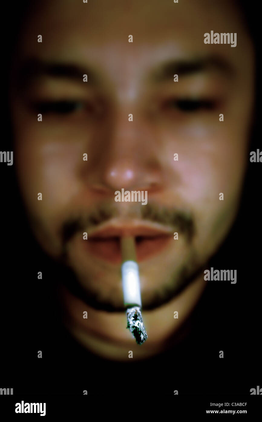 A close-up picture of a man's face smoking a cigarette Stock Photo - Alamy