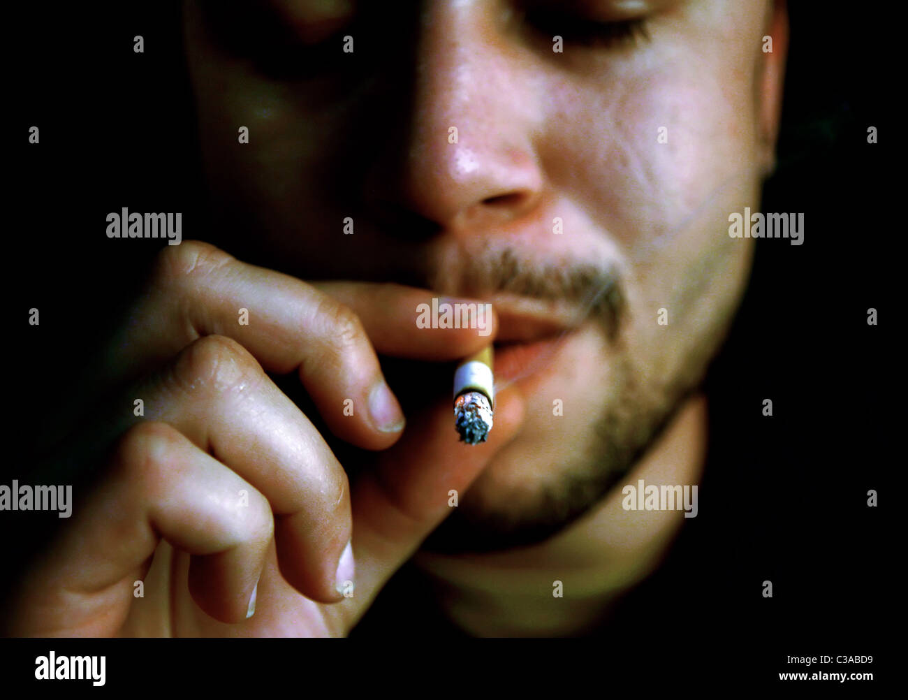 A close-up picture of a man's face smoking a cigarette Stock Photo - Alamy