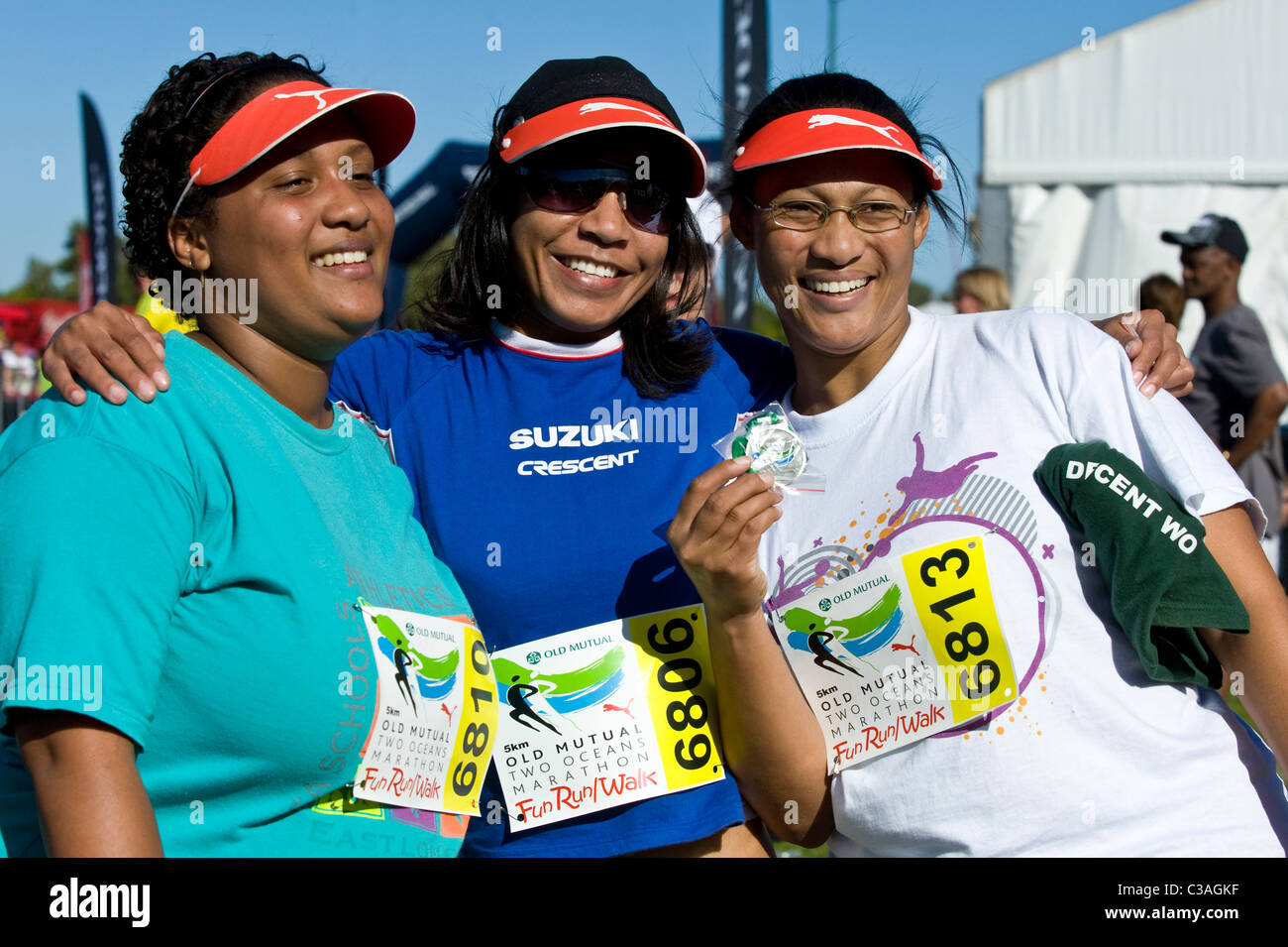 Three women pose after the 5km Fun Run, Two Oceans Marathon, Cape Town ...