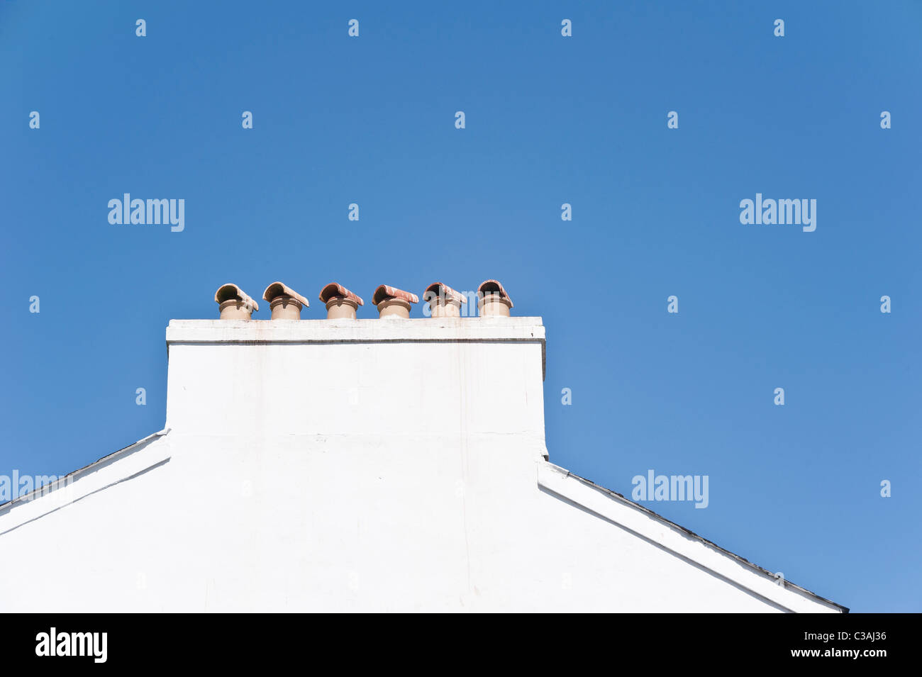White-painted gable end of a 19th century building with a chimney stack ...