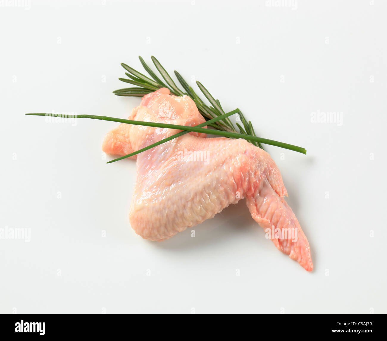 Raw chicken wing, chives and rosemary Stock Photo - Alamy