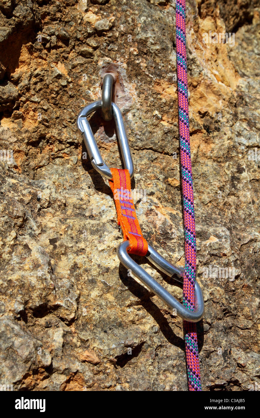 climbing shackles and rope on a rock wall vertical escalation Stock ...
