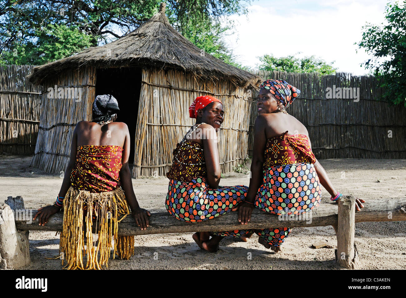 Women sitting on a bench, traditional village near Camp Kwando, Kwando ...