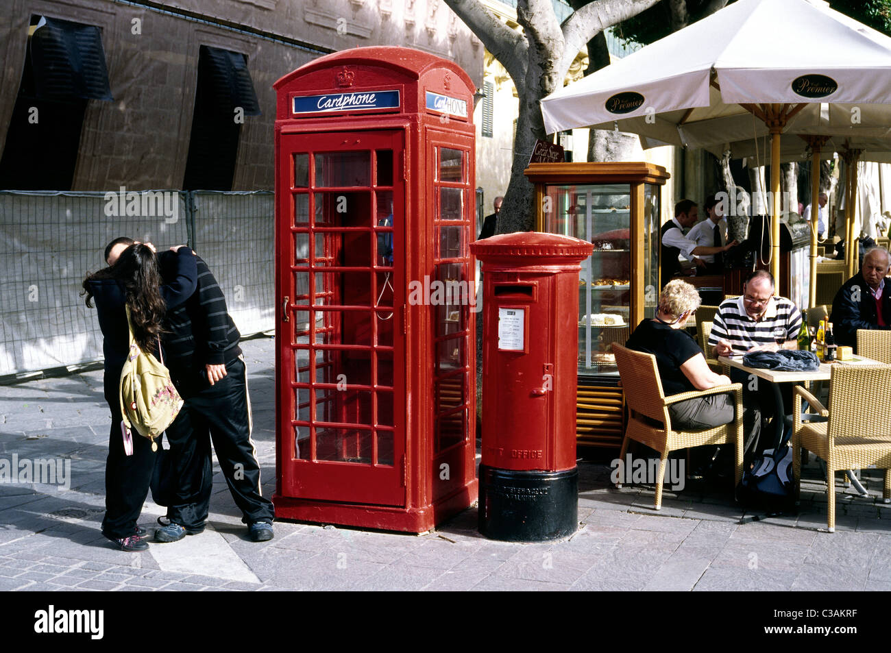 Young couple enjoying a private moment next to a British colonial phone ...