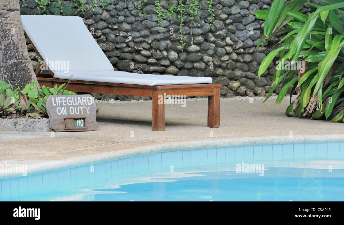 Lifeguard sign by swimming pool and sun-lounger Stock Photo - Alamy