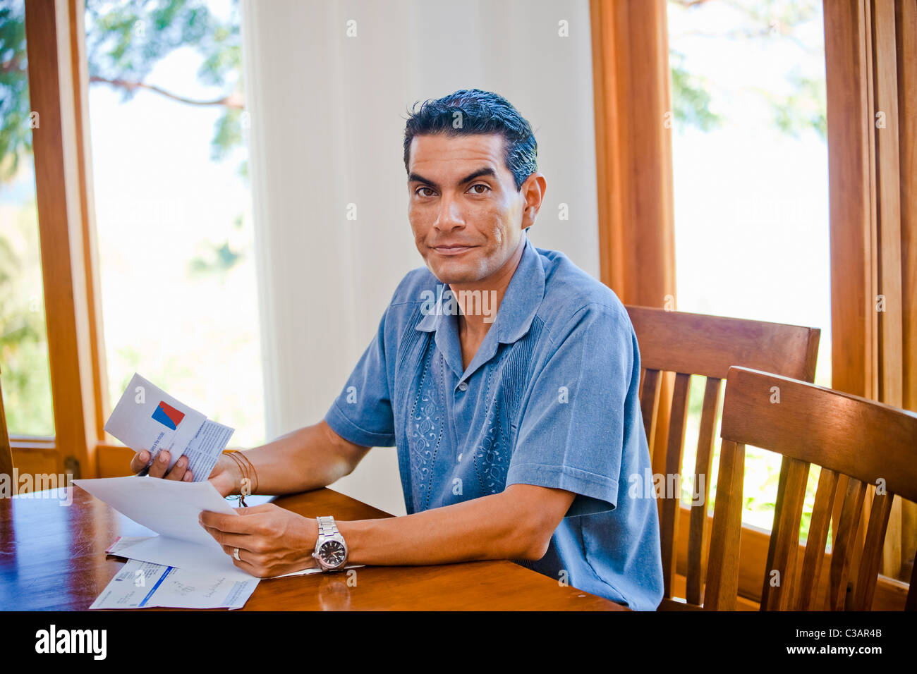 man at table with bills Stock Photo - Alamy