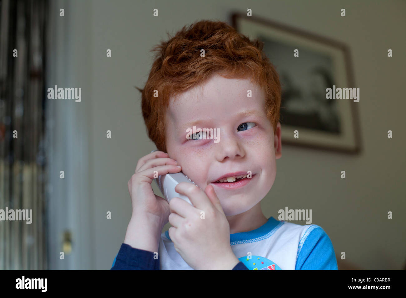 Seven year old red headed boy talking on the phone Stock Photo - Alamy