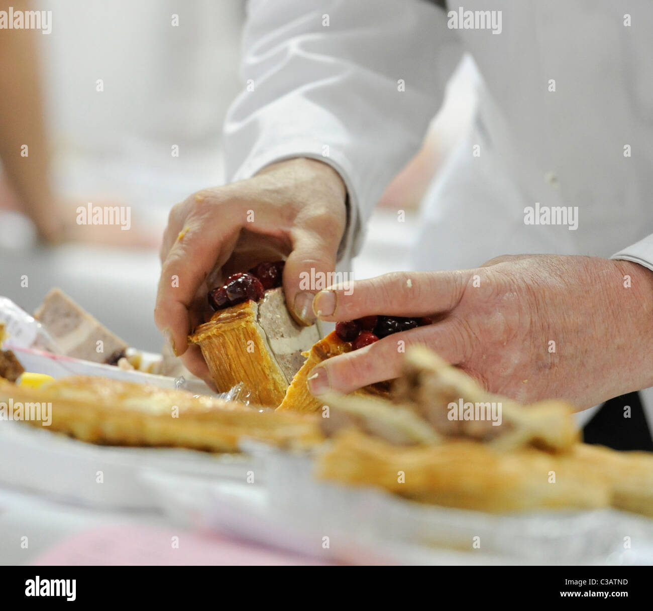 A judge inspects an entry at a UK national meat produce and pie ...