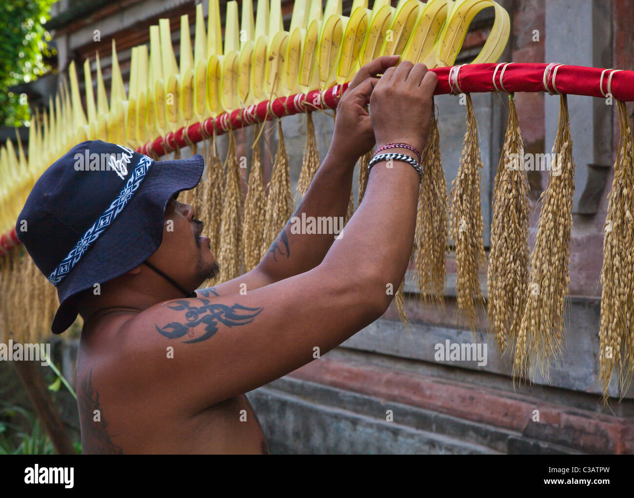 A man makes a PENJOR a symbol of the sacred Mount Agung as an offering ...