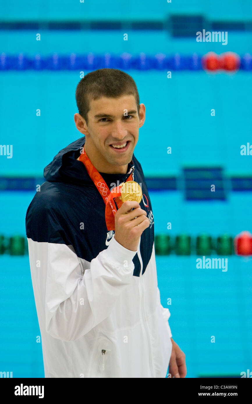 Michael Phelps (USA) shows off his gold medal for winning the 200m ...