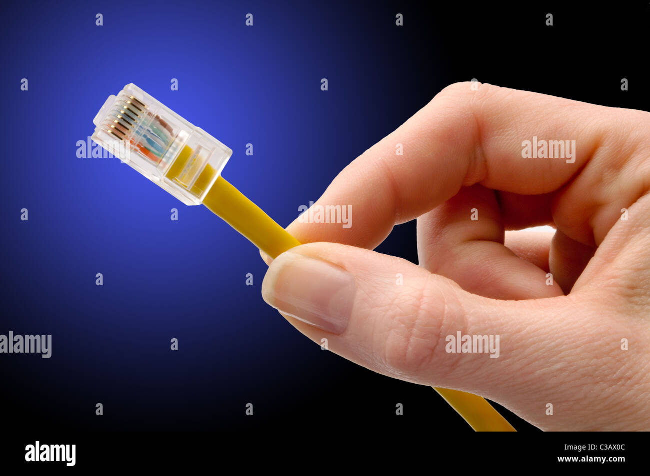 hand holding cat 5 network cable in fingers Stock Photo - Alamy
