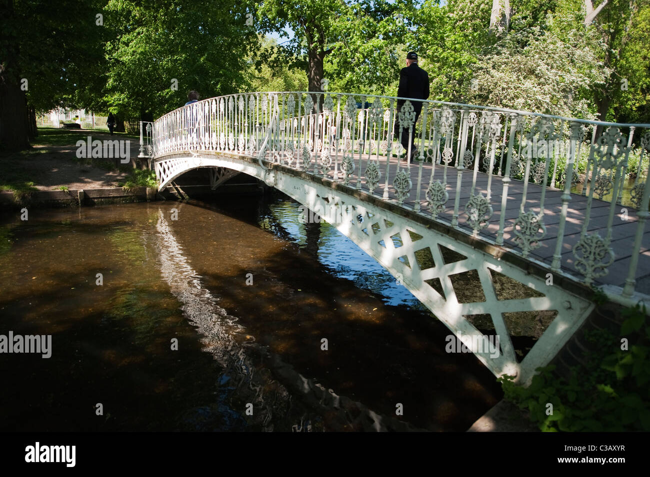 Ornate wrought iron bridge crosses the river Wandle in Morden Hall Park ...