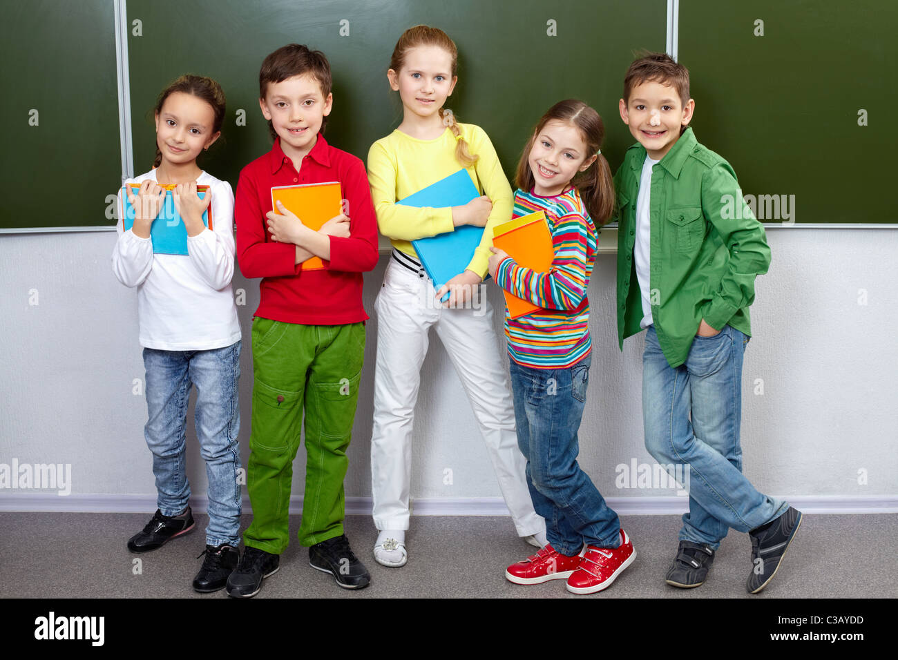 Portrait of five pupils looking at camera in classroom Stock Photo - Alamy