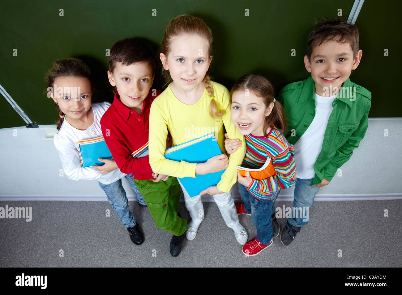 Portrait of five pupils looking at camera in classroom Stock Photo - Alamy