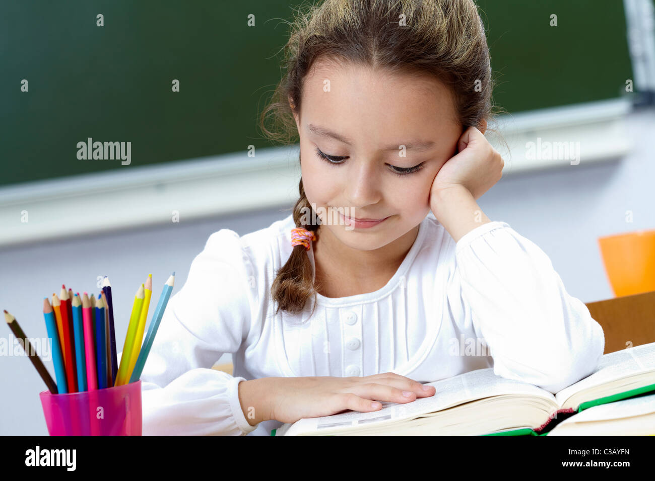 Portrait of pretty girl reading at workplace Stock Photo - Alamy