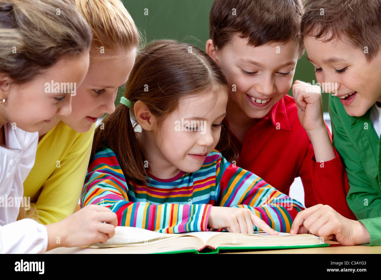 Portrait of friendly group reading book in classroom Stock Photo - Alamy