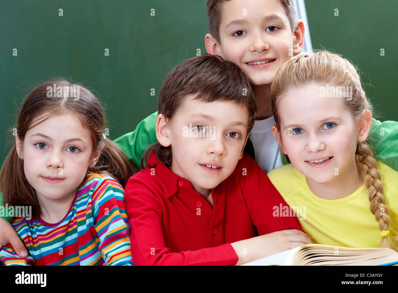 Team of four classmates looking at camera in classroom Stock Photo - Alamy
